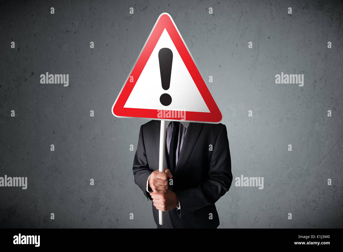 Businessman holding an exclamation road sign Stock Photo - Alamy