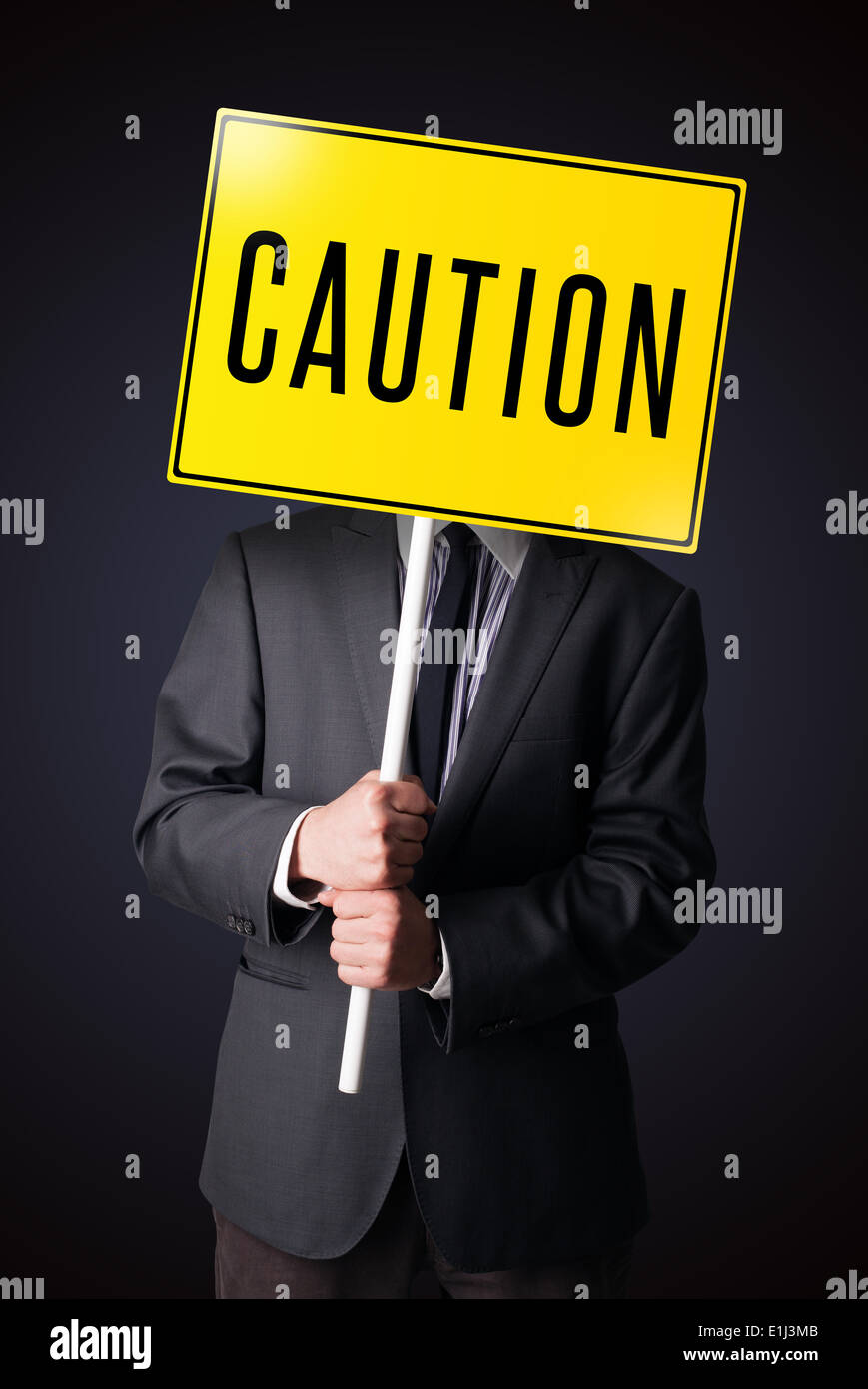 Businessman holding a caution sign Stock Photo - Alamy