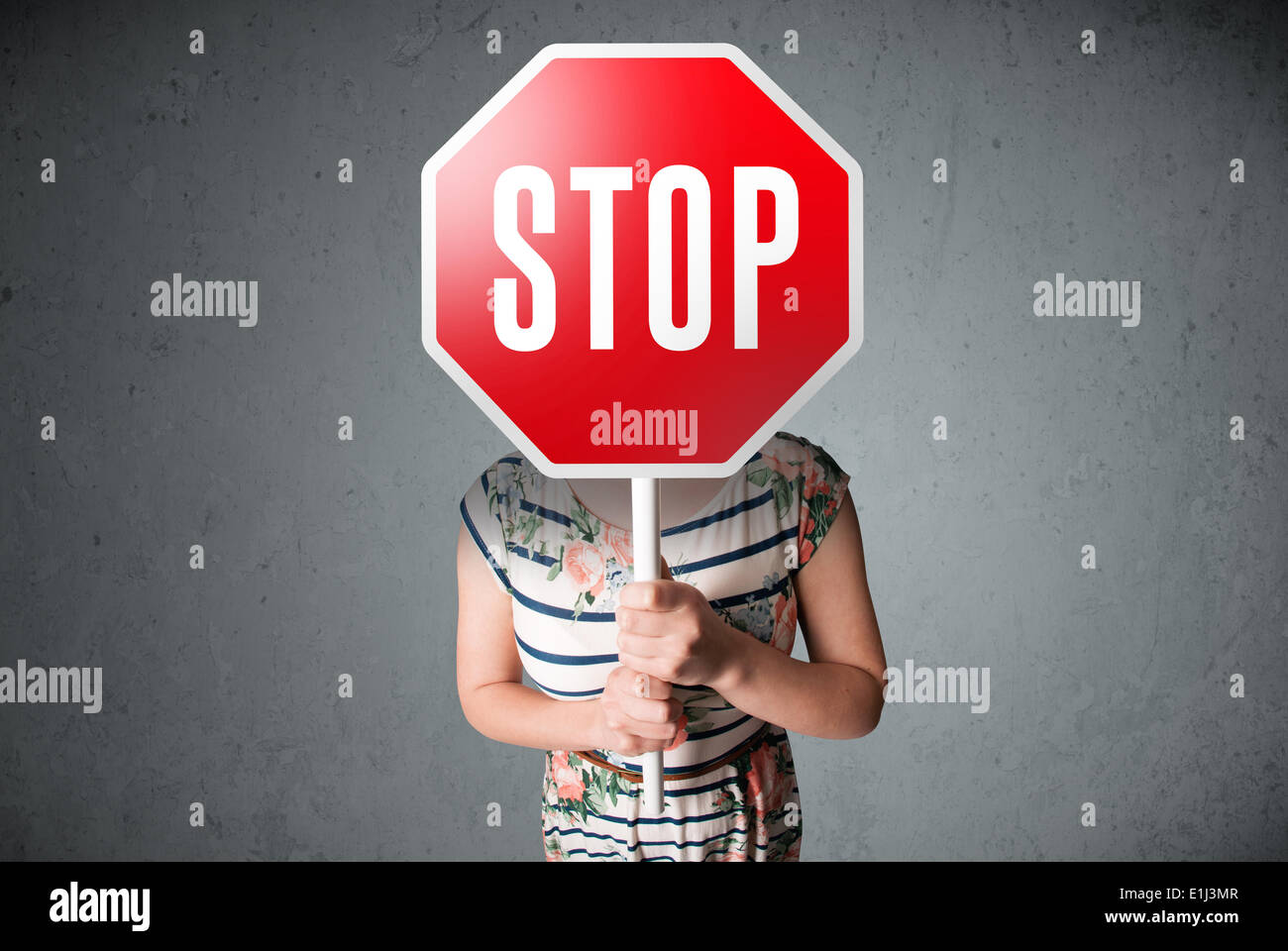 Young woman holding a stop sign Stock Photo - Alamy