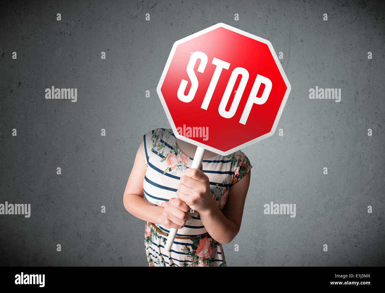 Young woman holding a stop sign Stock Photo - Alamy