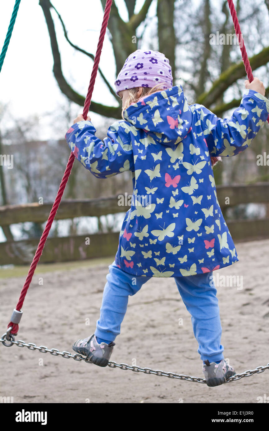 Little girl balancing on chain at playground Stock Photo - Alamy