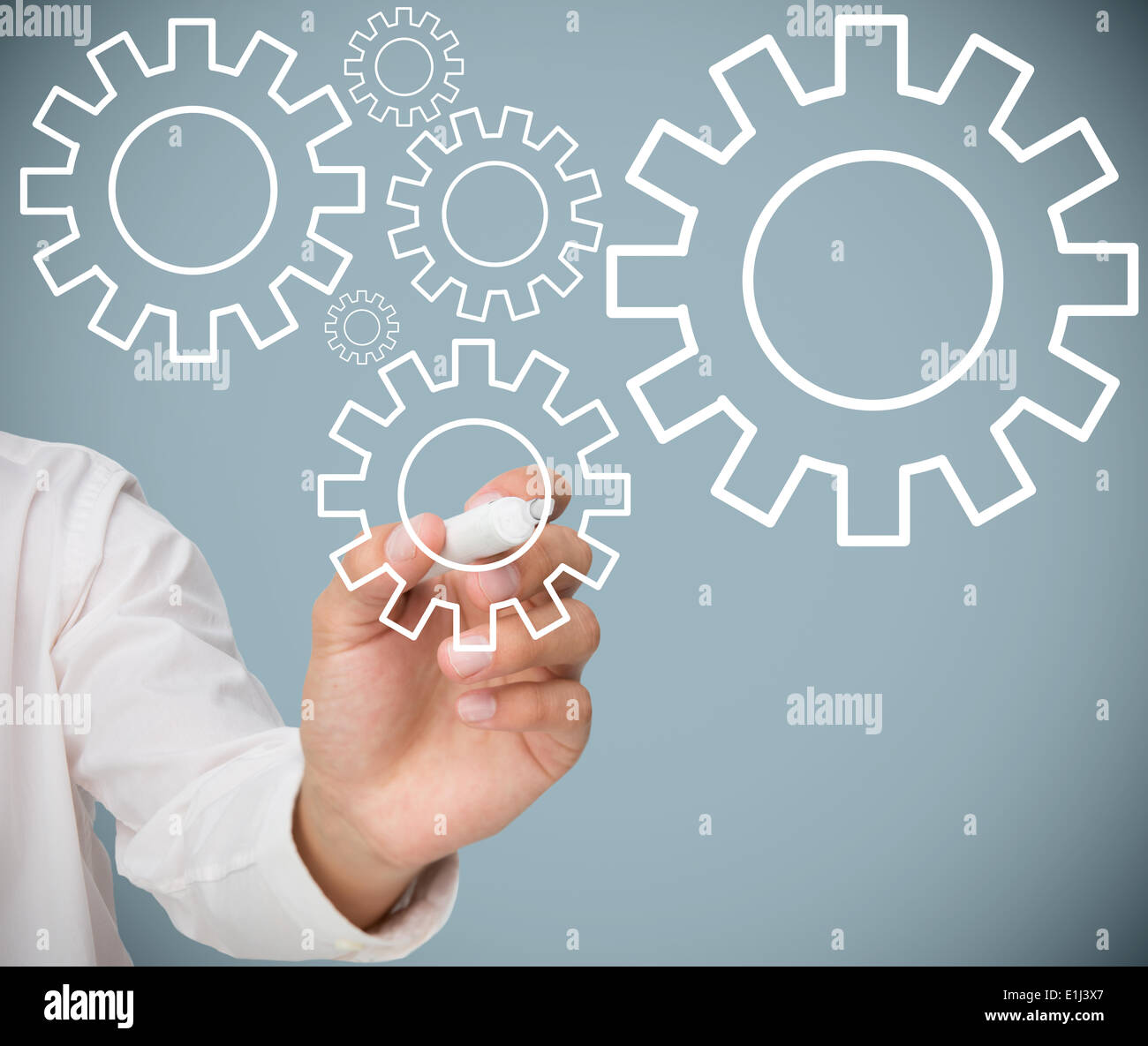 Businessman drawing cogs and wheels Stock Photo - Alamy