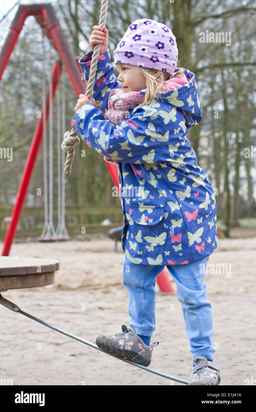 Little girl balancing on chain at playground Stock Photo - Alamy