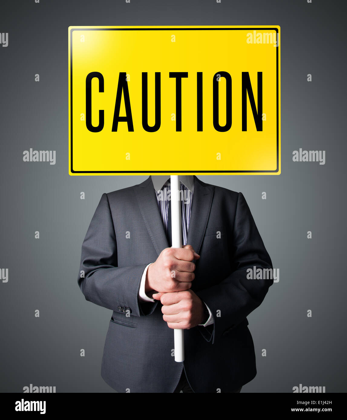 Businessman holding a caution sign Stock Photo - Alamy