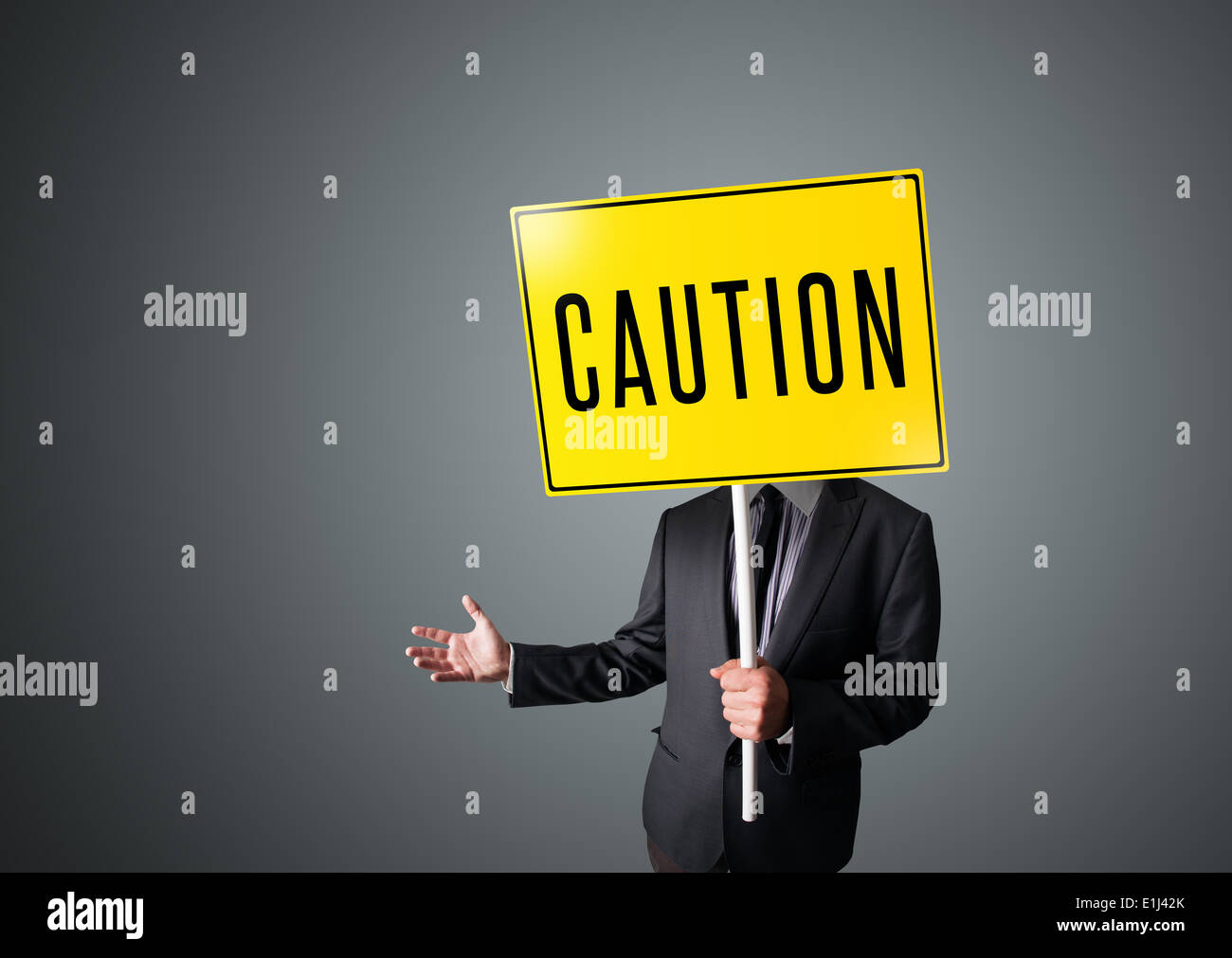 Businessman holding a caution sign Stock Photo - Alamy