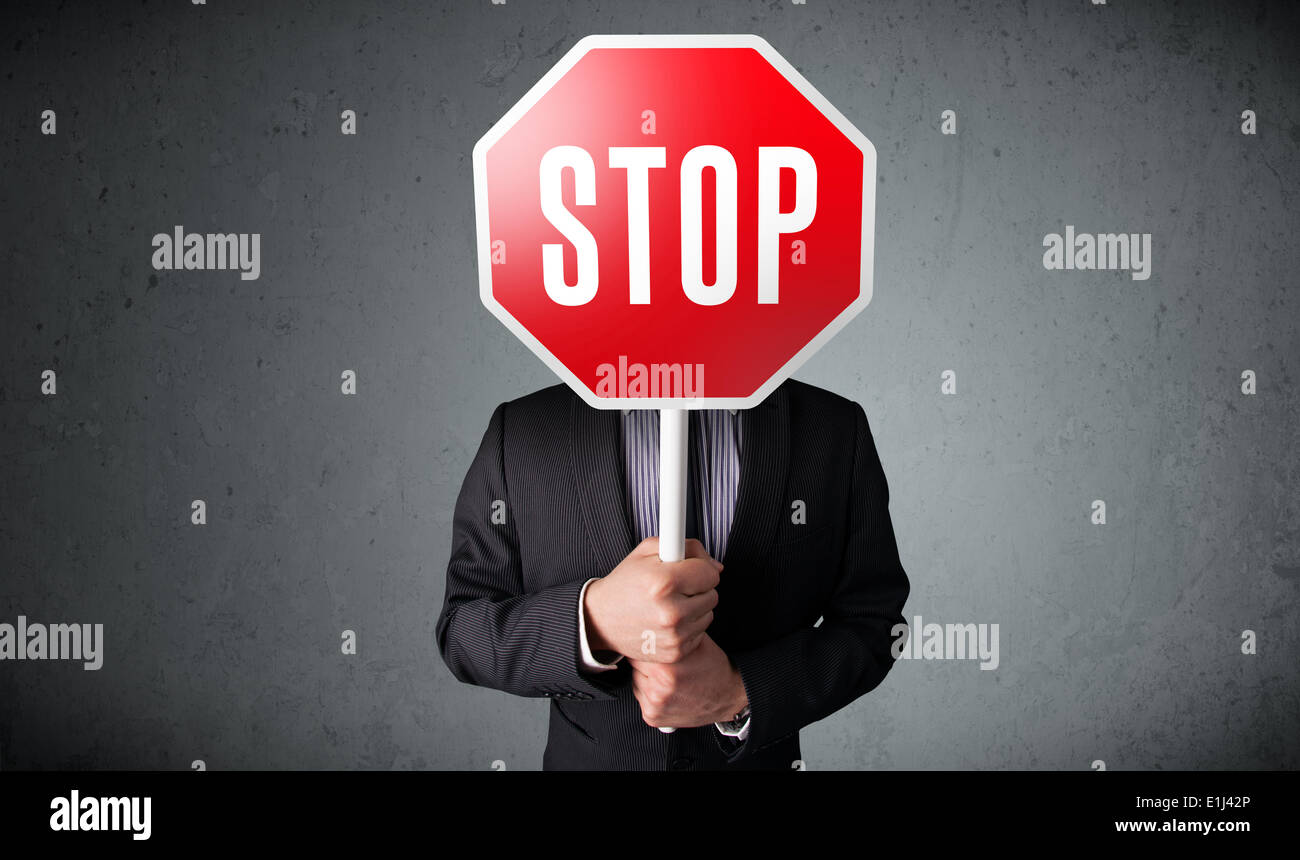 Businessman holding a stop sign Stock Photo - Alamy