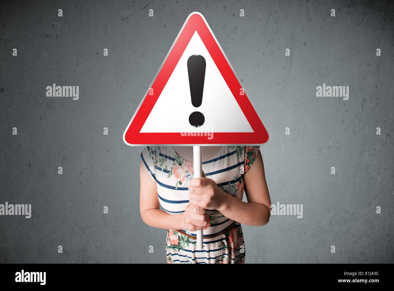 Young woman holding an exclamation road sign Stock Photo - Alamy