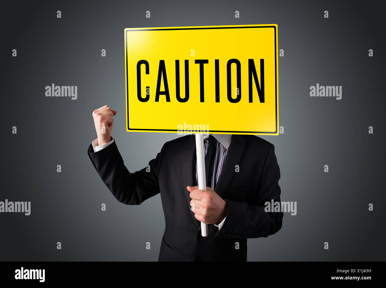 Businessman holding a caution sign Stock Photo - Alamy