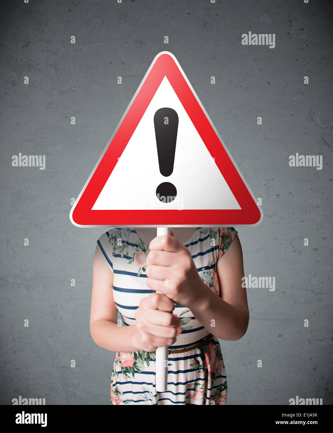 Young woman holding an exclamation road sign Stock Photo - Alamy