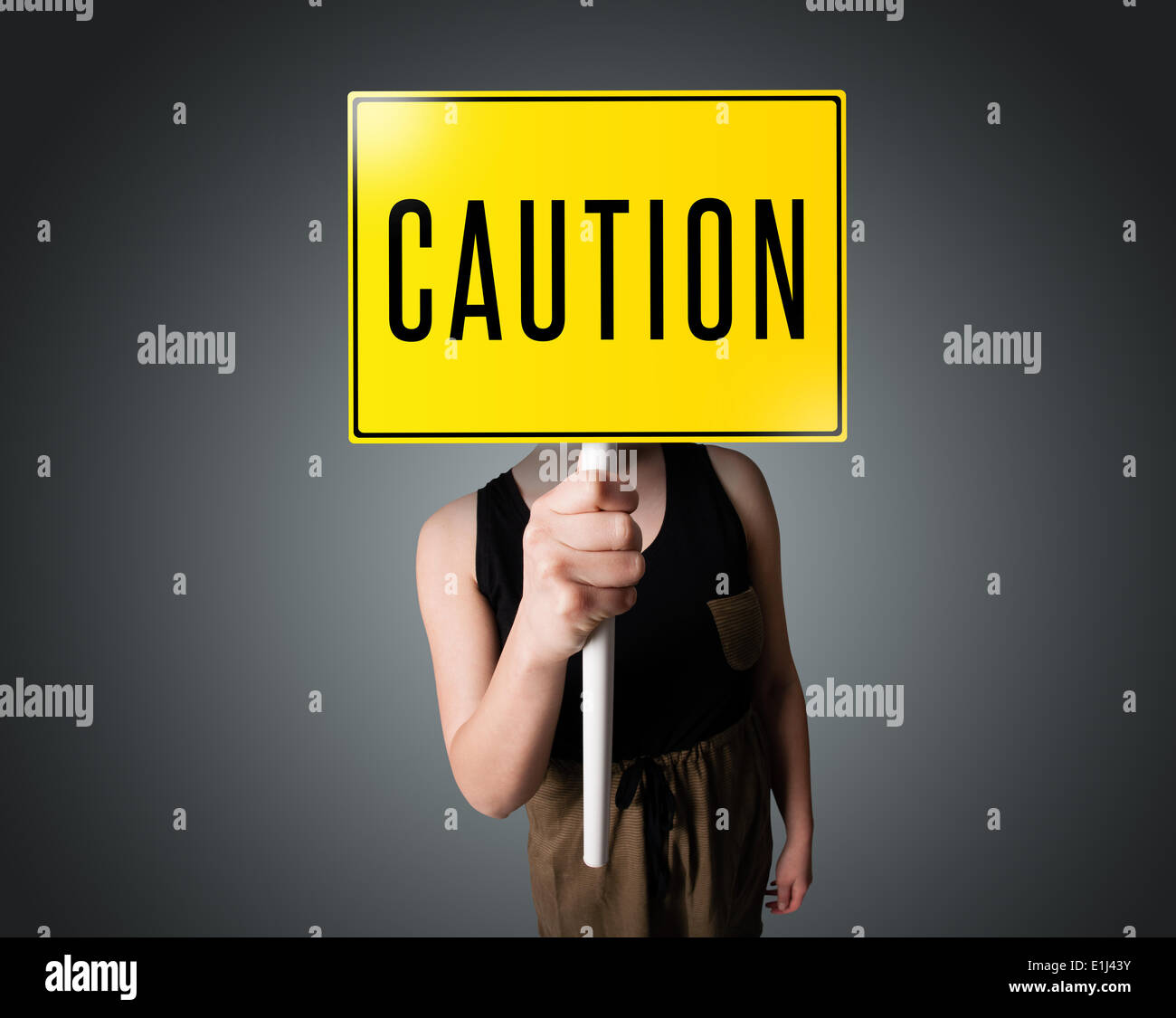 Young woman holding a caution sign Stock Photo - Alamy