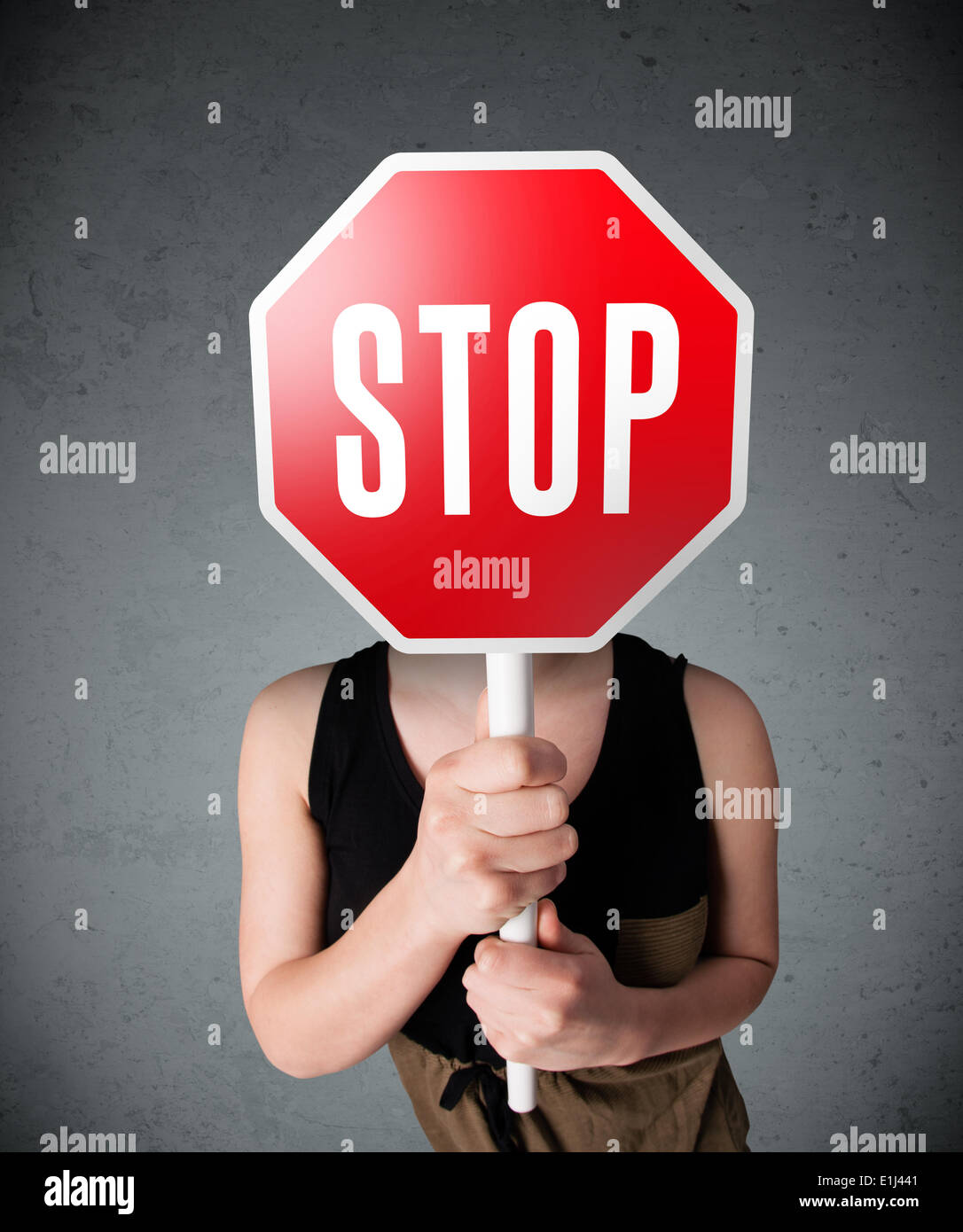 Young woman holding a stop sign Stock Photo - Alamy