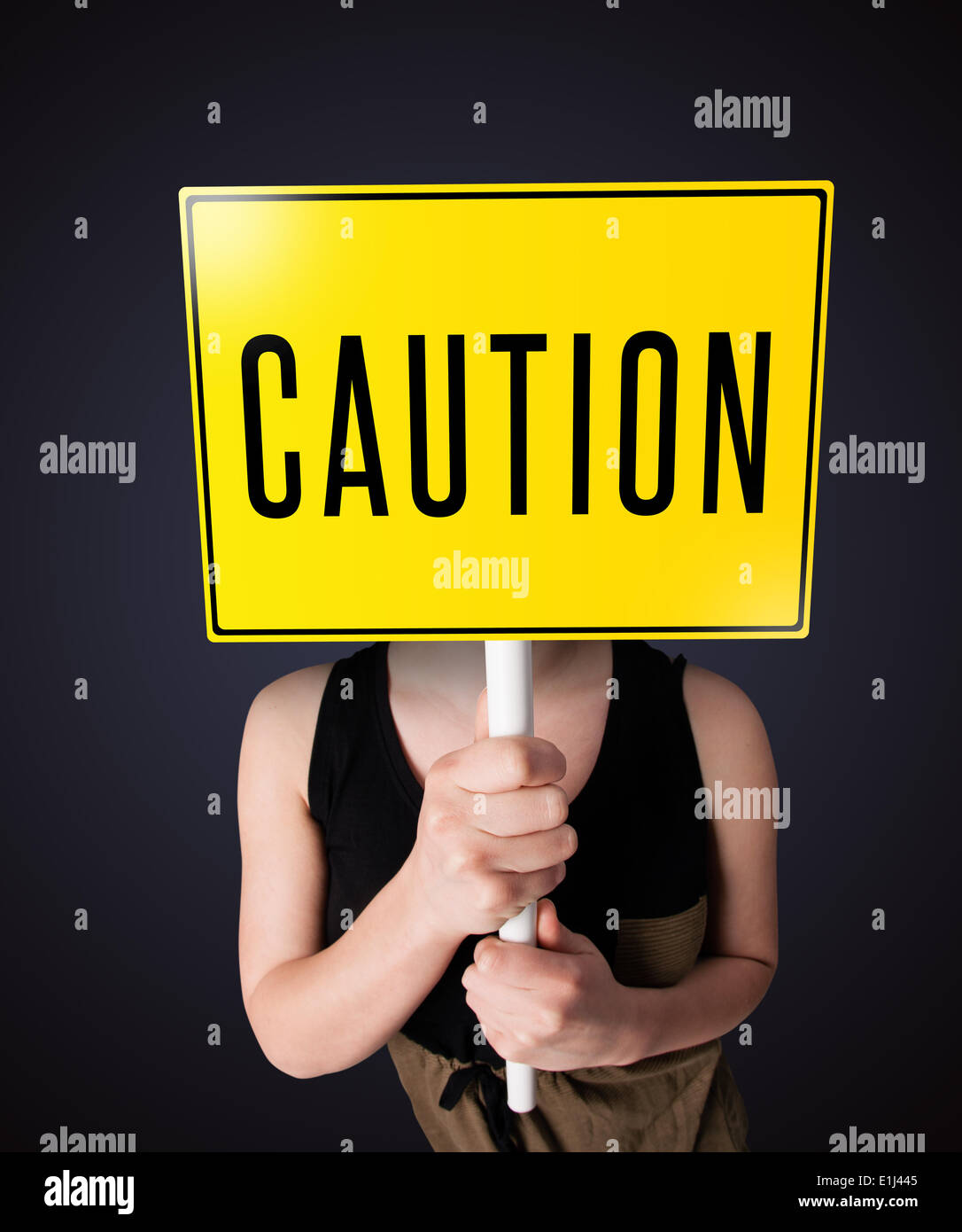 Young woman holding a caution sign Stock Photo - Alamy