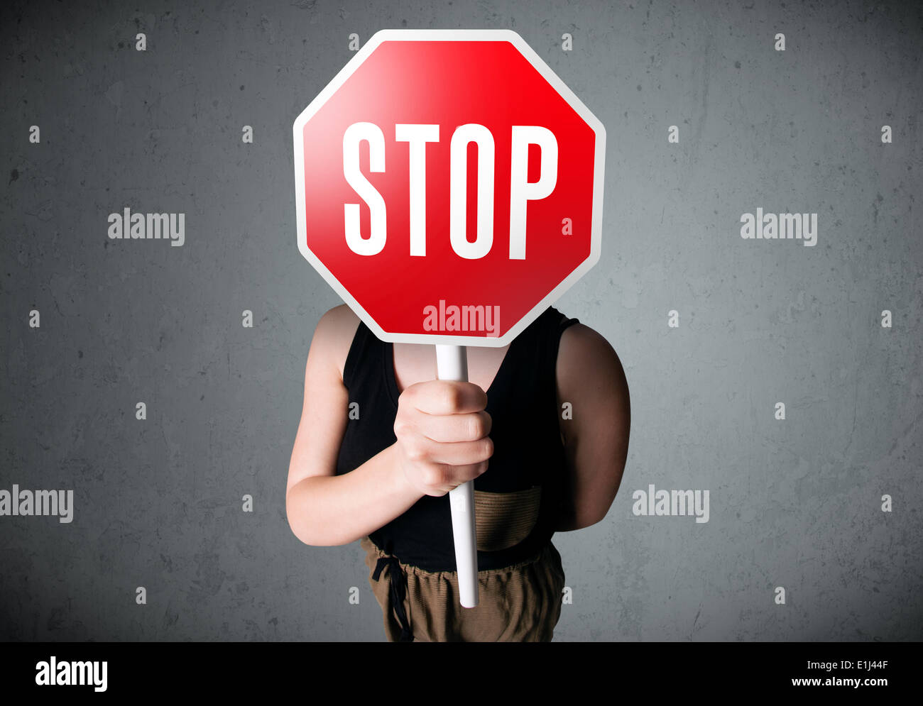 Young woman holding a stop sign Stock Photo - Alamy
