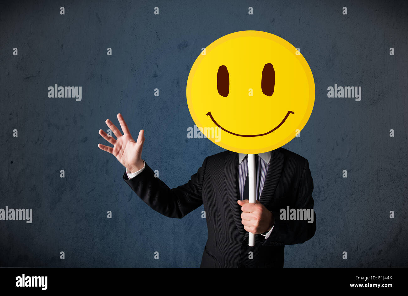 Businessman holding a smiley face emoticon Stock Photo - Alamy