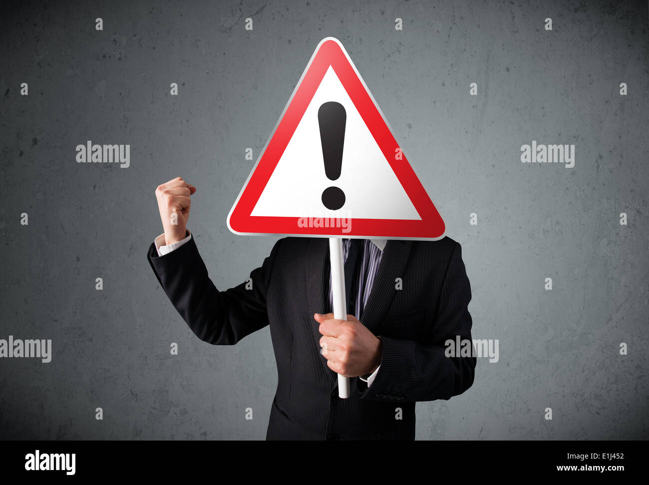 Businessman holding an exclamation road sign Stock Photo - Alamy
