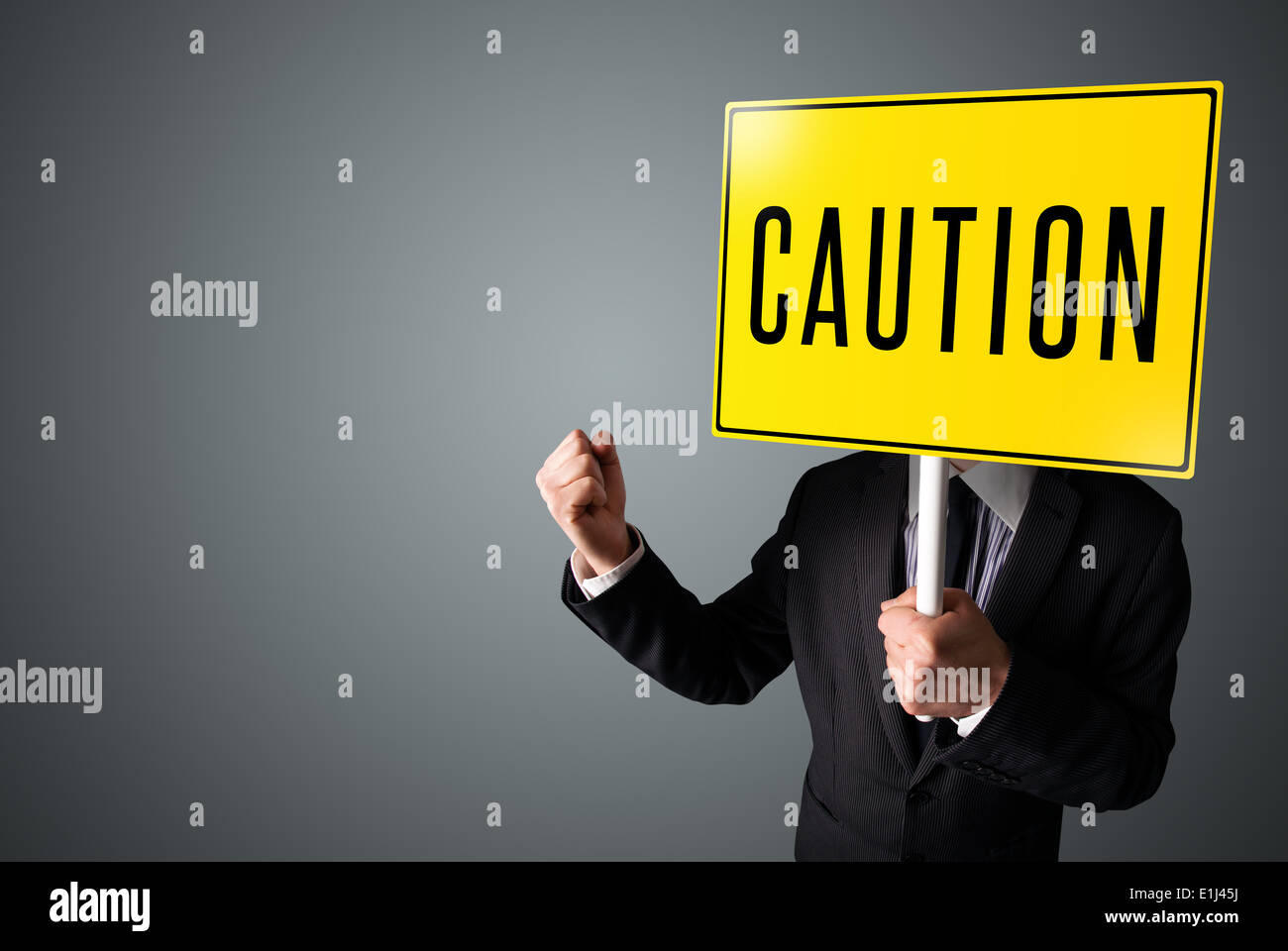 Businessman holding a caution sign Stock Photo - Alamy