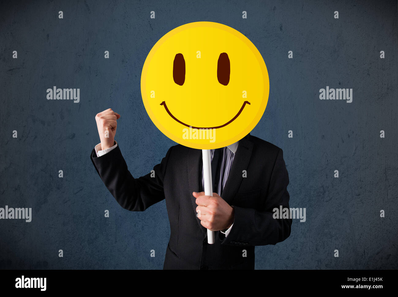 Businessman holding a smiley face emoticon Stock Photo - Alamy