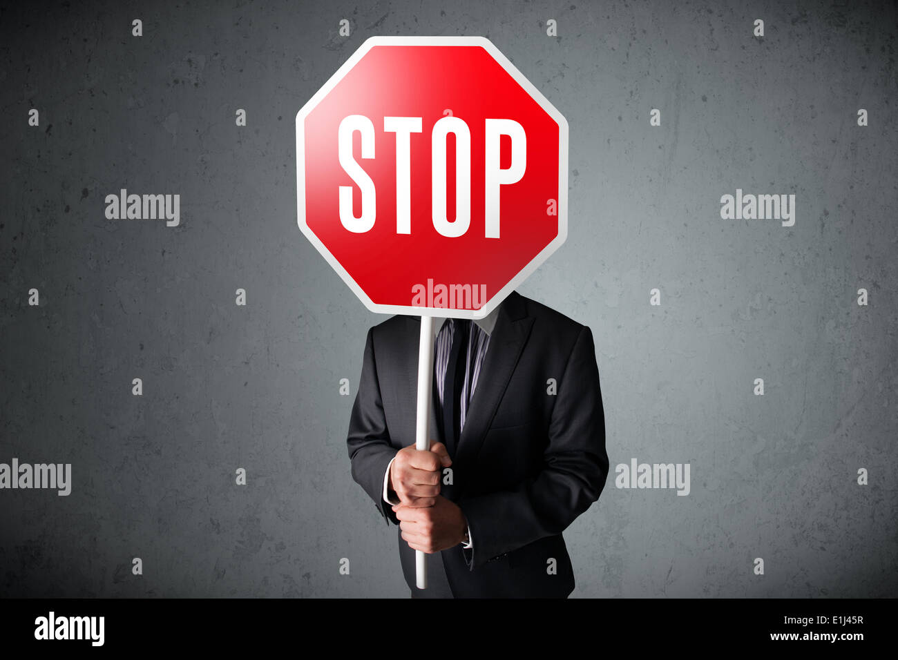 Businessman holding a stop sign Stock Photo - Alamy