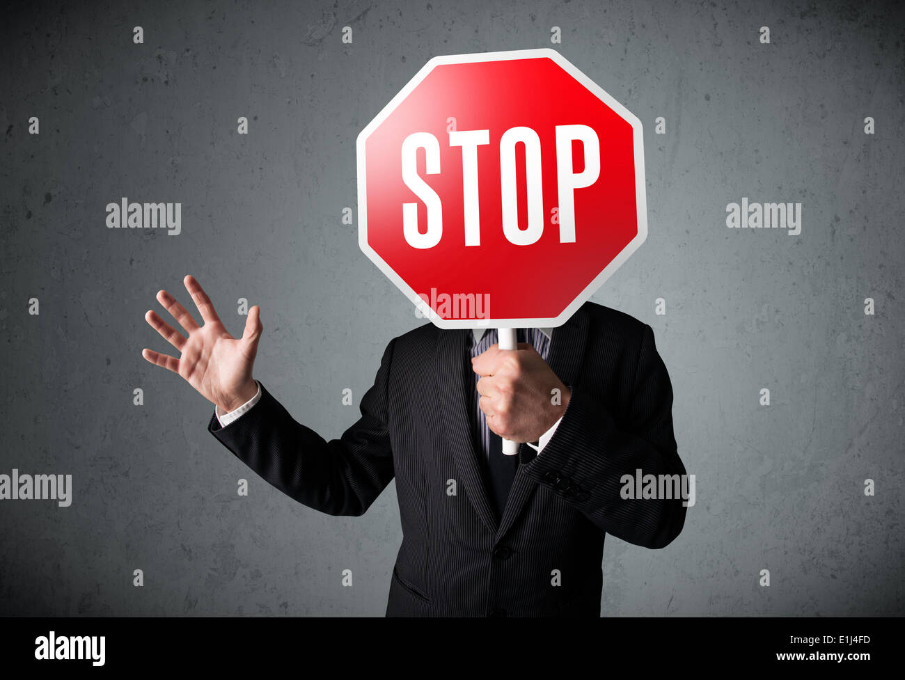 Businessman holding a stop sign Stock Photo - Alamy