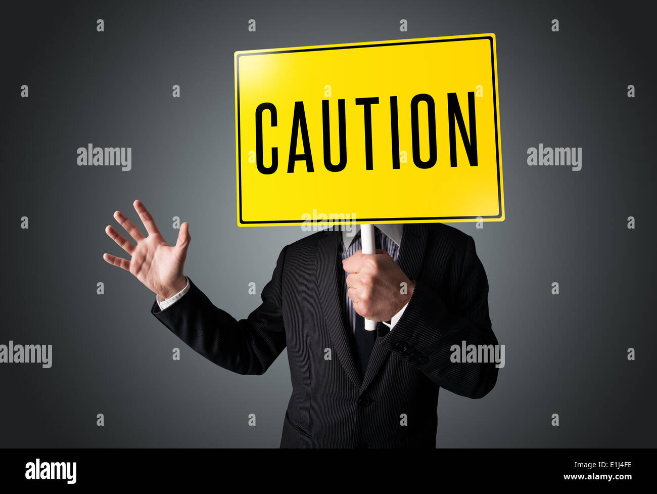 Businessman holding a caution sign Stock Photo - Alamy