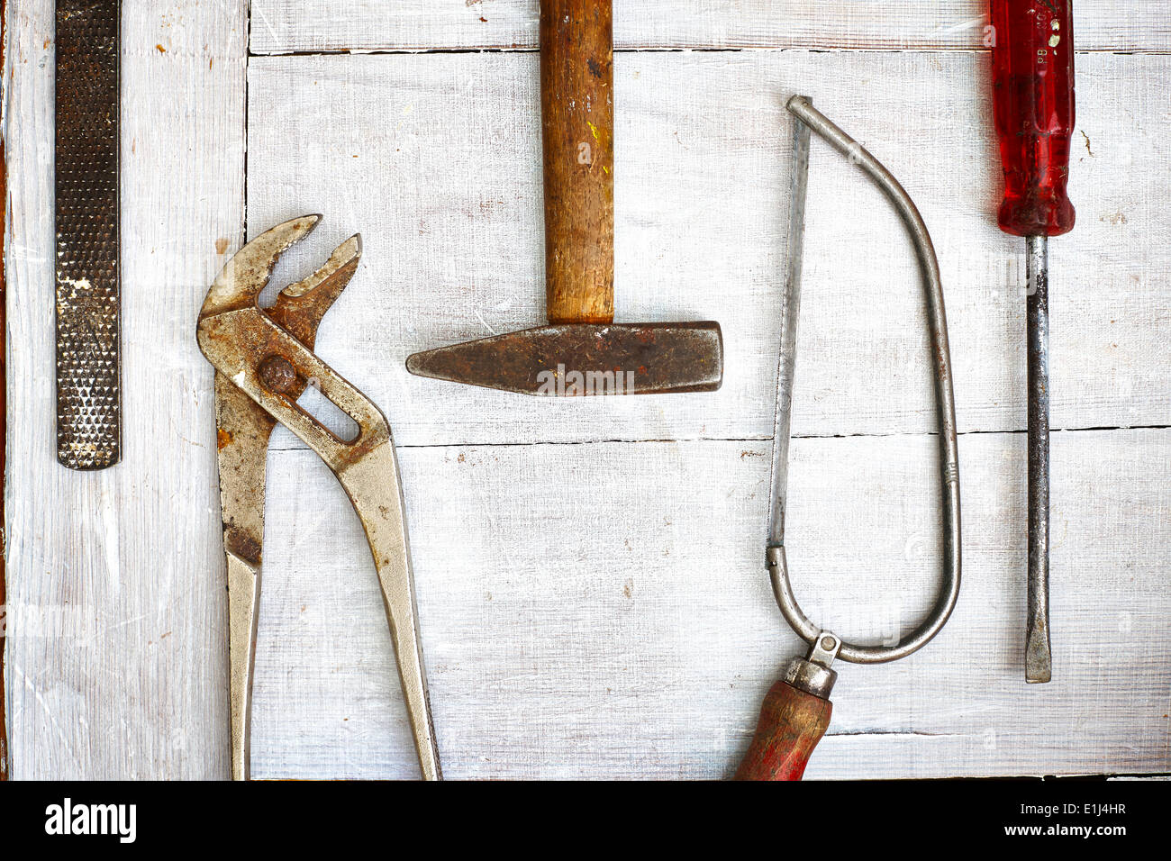 File, gripper, hammer, saw and screw driver on grey wood, elevated view ...