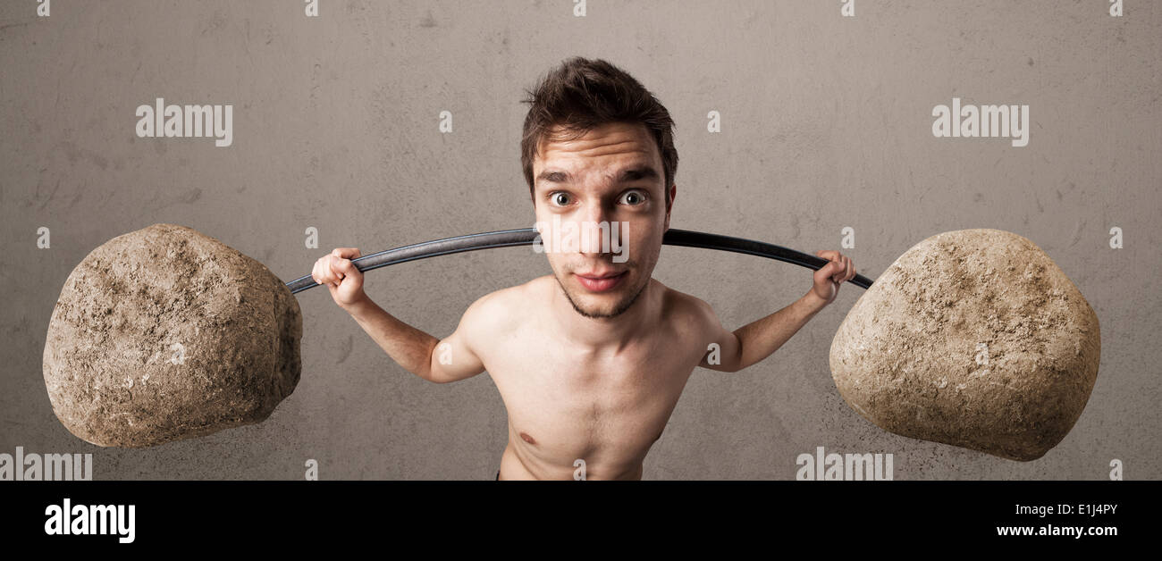 skinny guy lifting large rock stone weights Stock Photo - Alamy