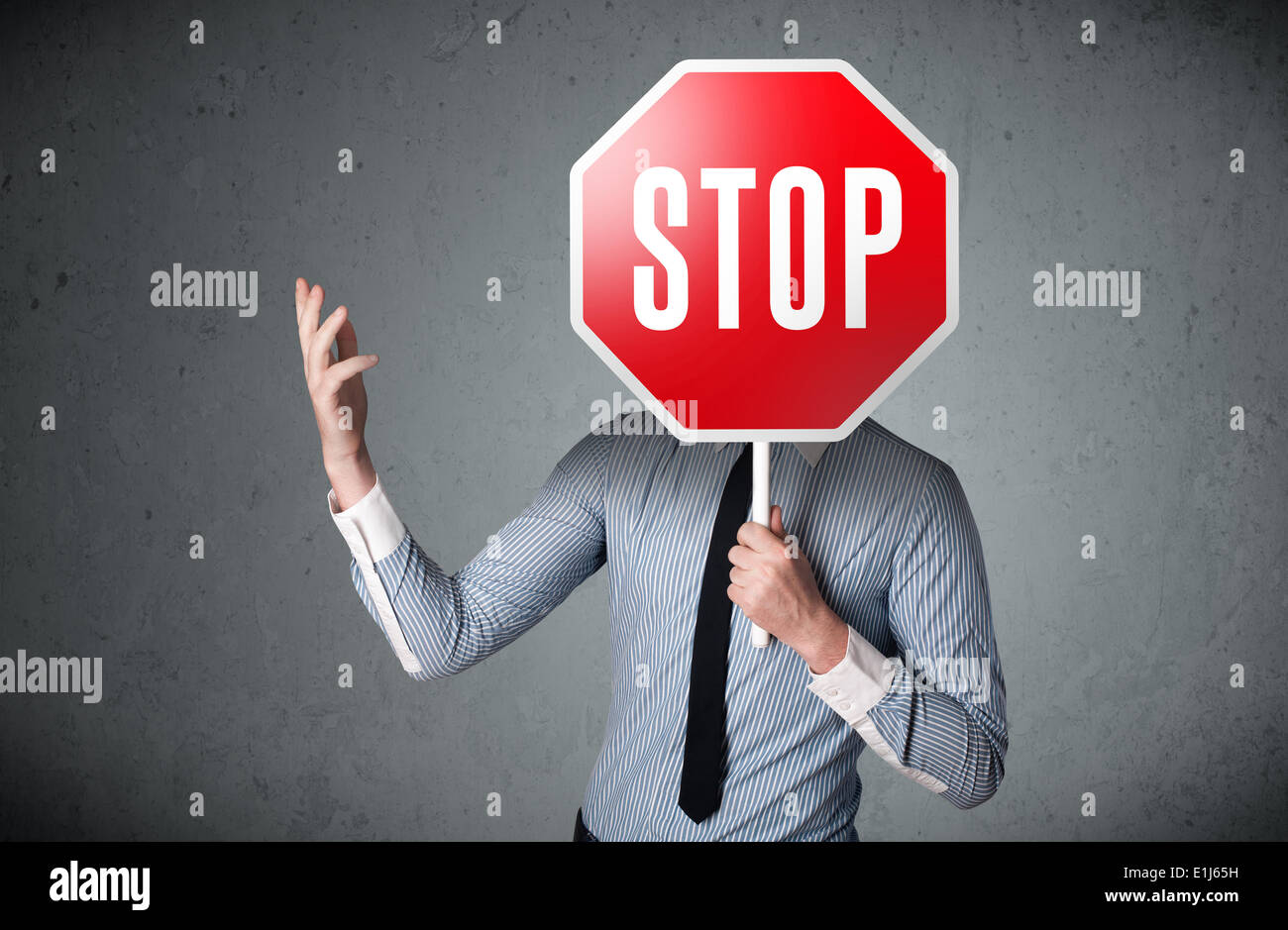 Businessman holding a stop sign Stock Photo - Alamy