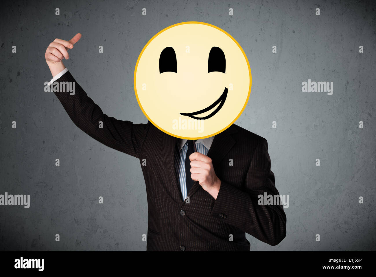 Businessman holding a smiley face emoticon Stock Photo - Alamy