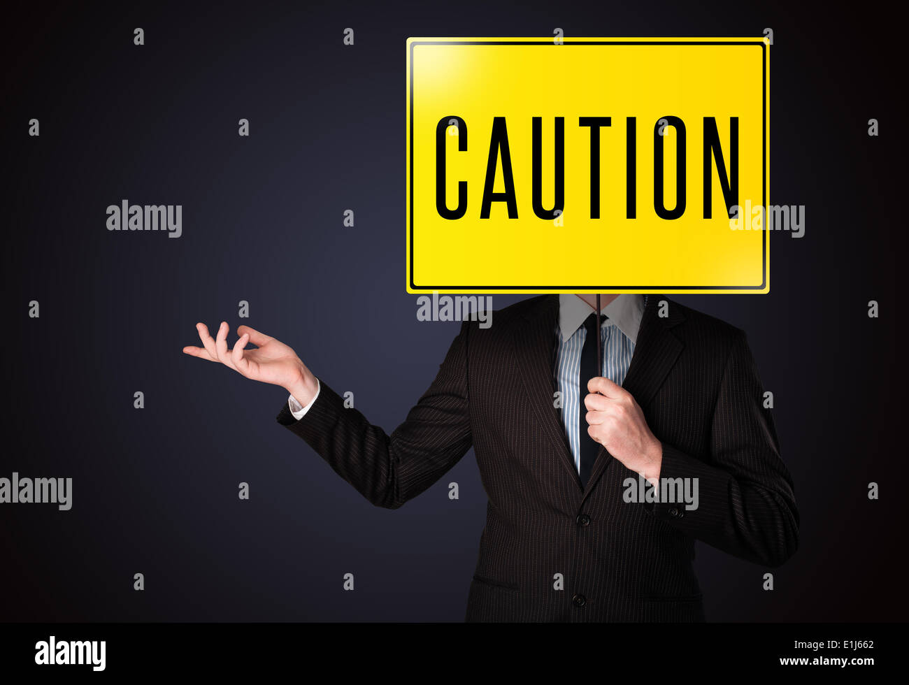 Businessman holding a caution sign Stock Photo - Alamy