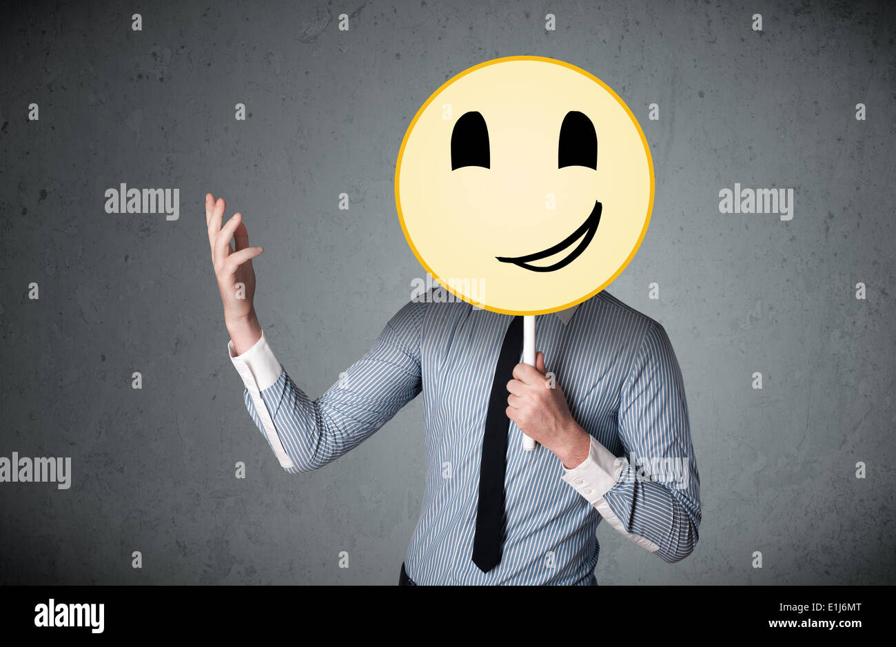 Businessman holding a smiley face emoticon Stock Photo - Alamy