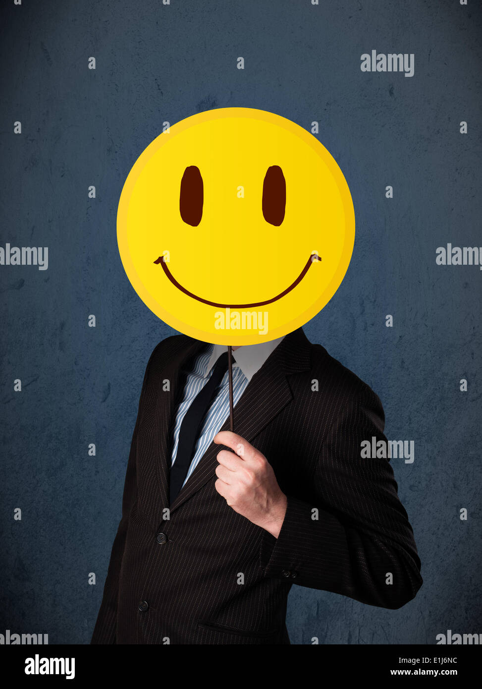 Businessman holding a smiley face emoticon Stock Photo - Alamy