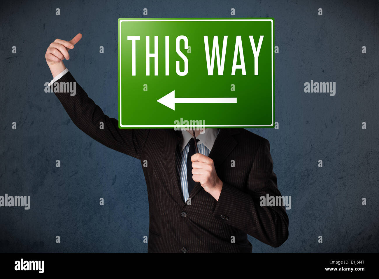 Businessman holding a direction sign Stock Photo - Alamy