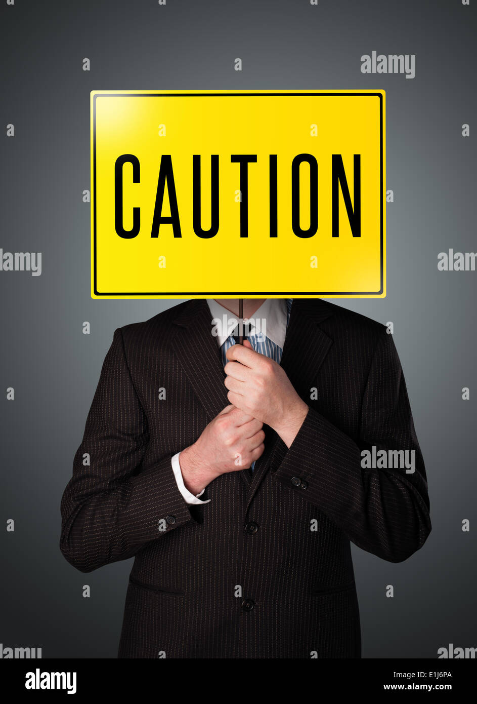 Businessman holding a caution sign Stock Photo - Alamy