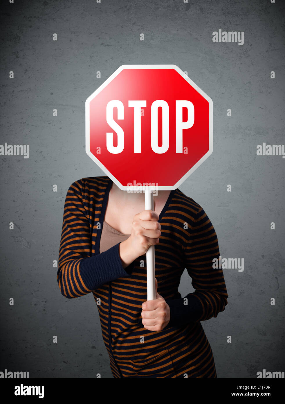 Young woman holding a stop sign Stock Photo - Alamy