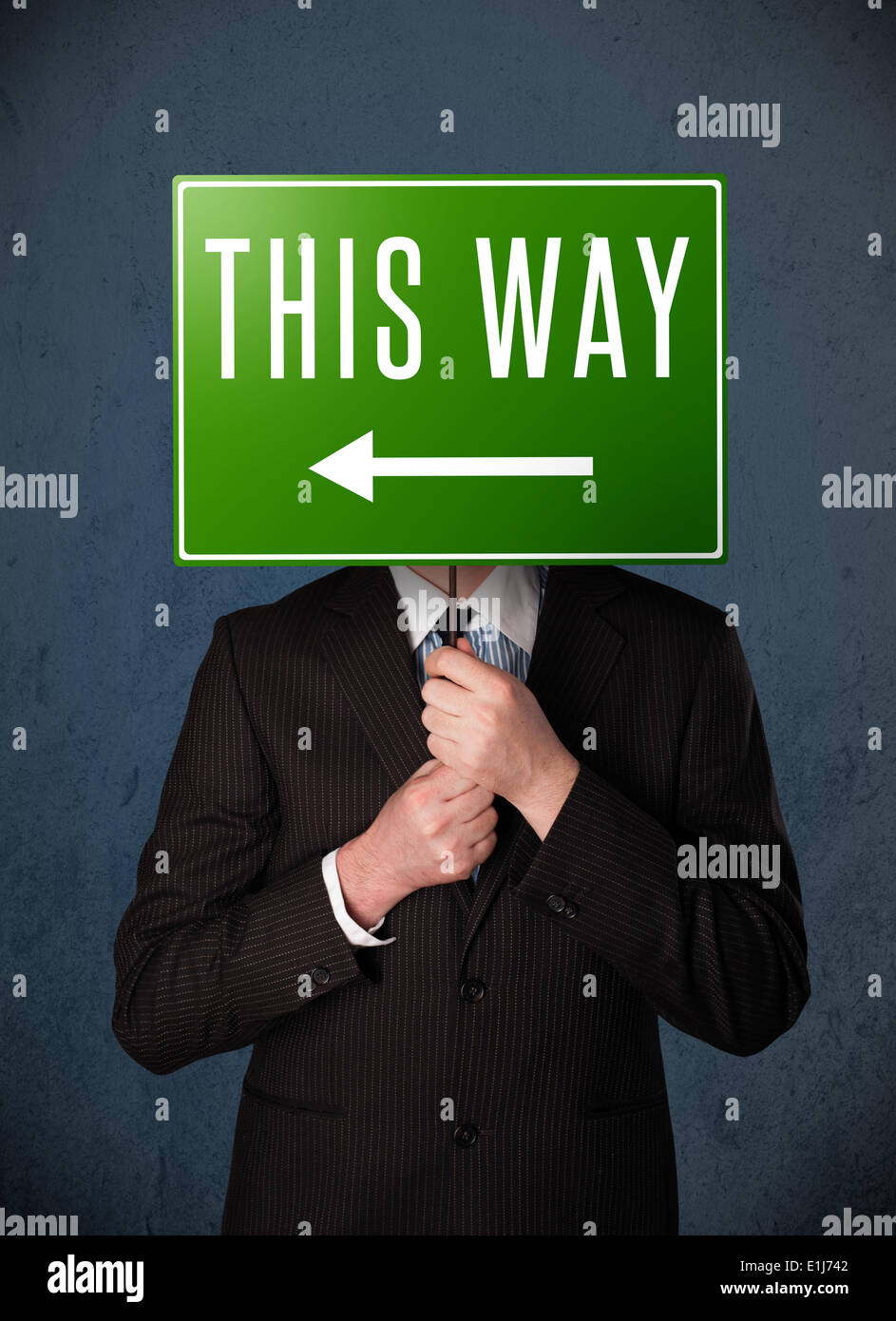 Businessman holding a direction sign Stock Photo - Alamy