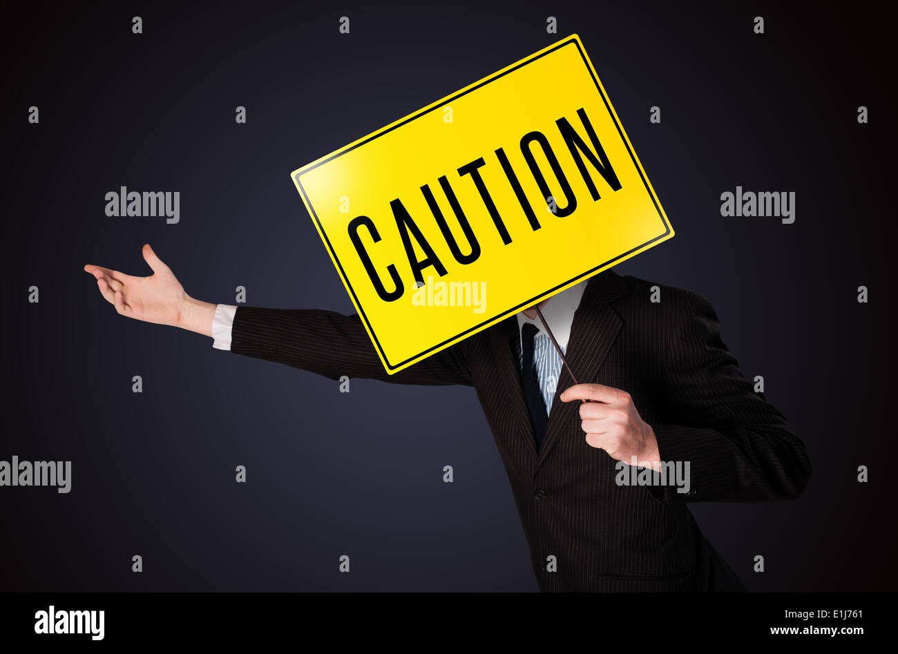 Businessman holding a caution sign Stock Photo - Alamy