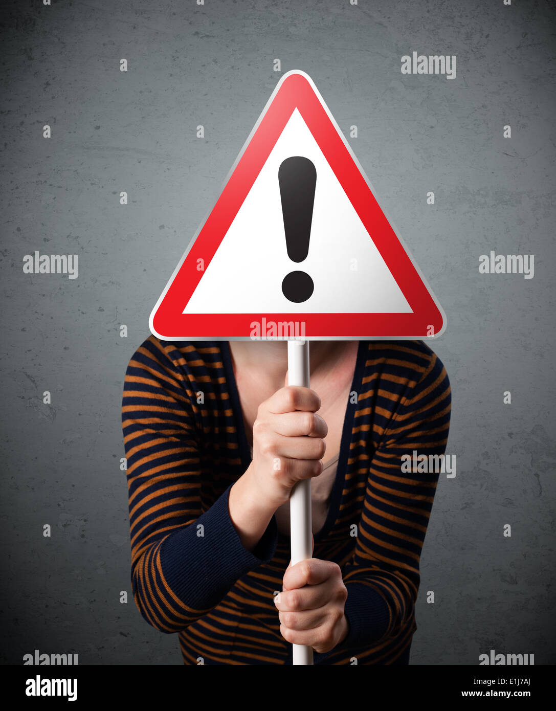 Young woman holding an exclamation road sign Stock Photo - Alamy