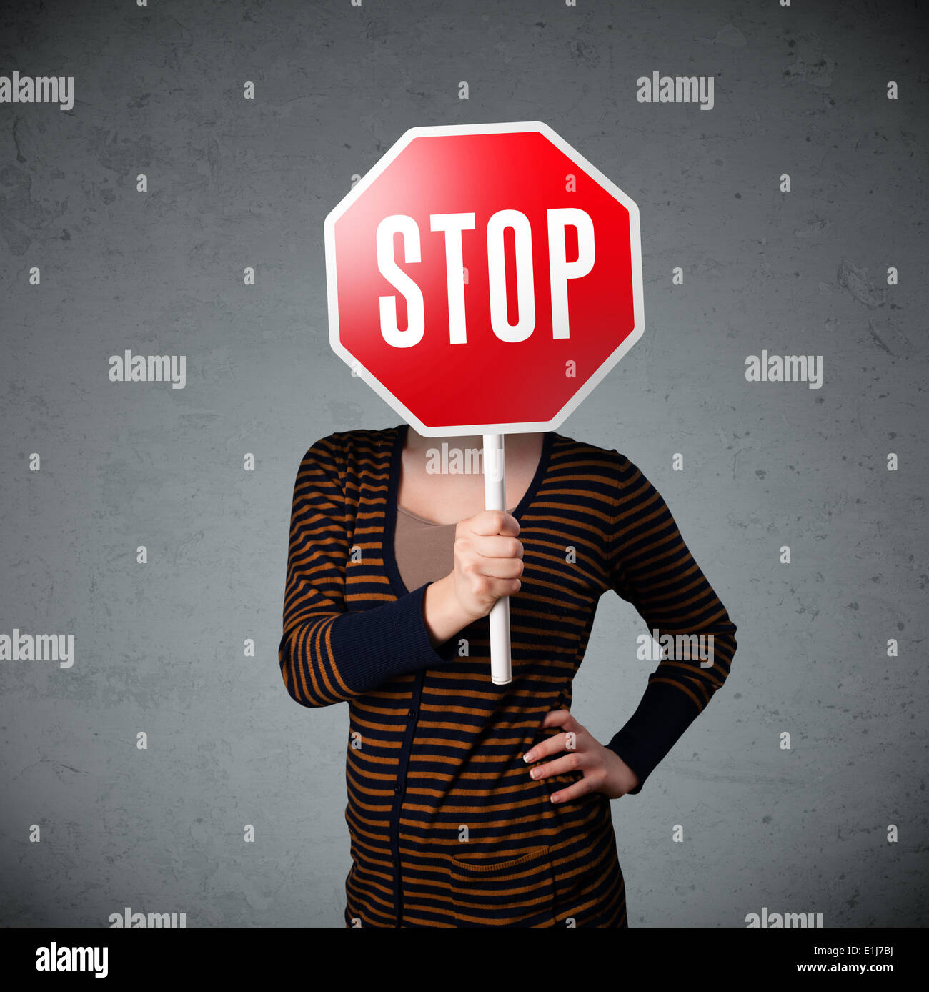 Young woman holding a stop sign Stock Photo - Alamy
