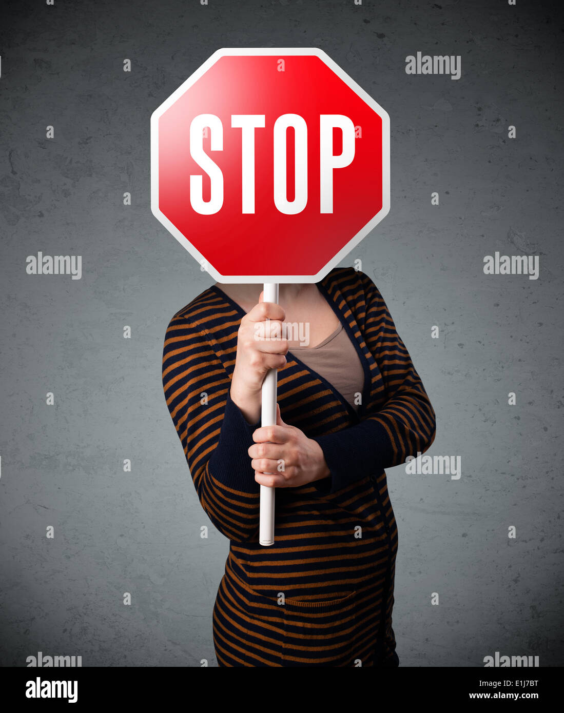 Young woman holding a stop sign Stock Photo - Alamy