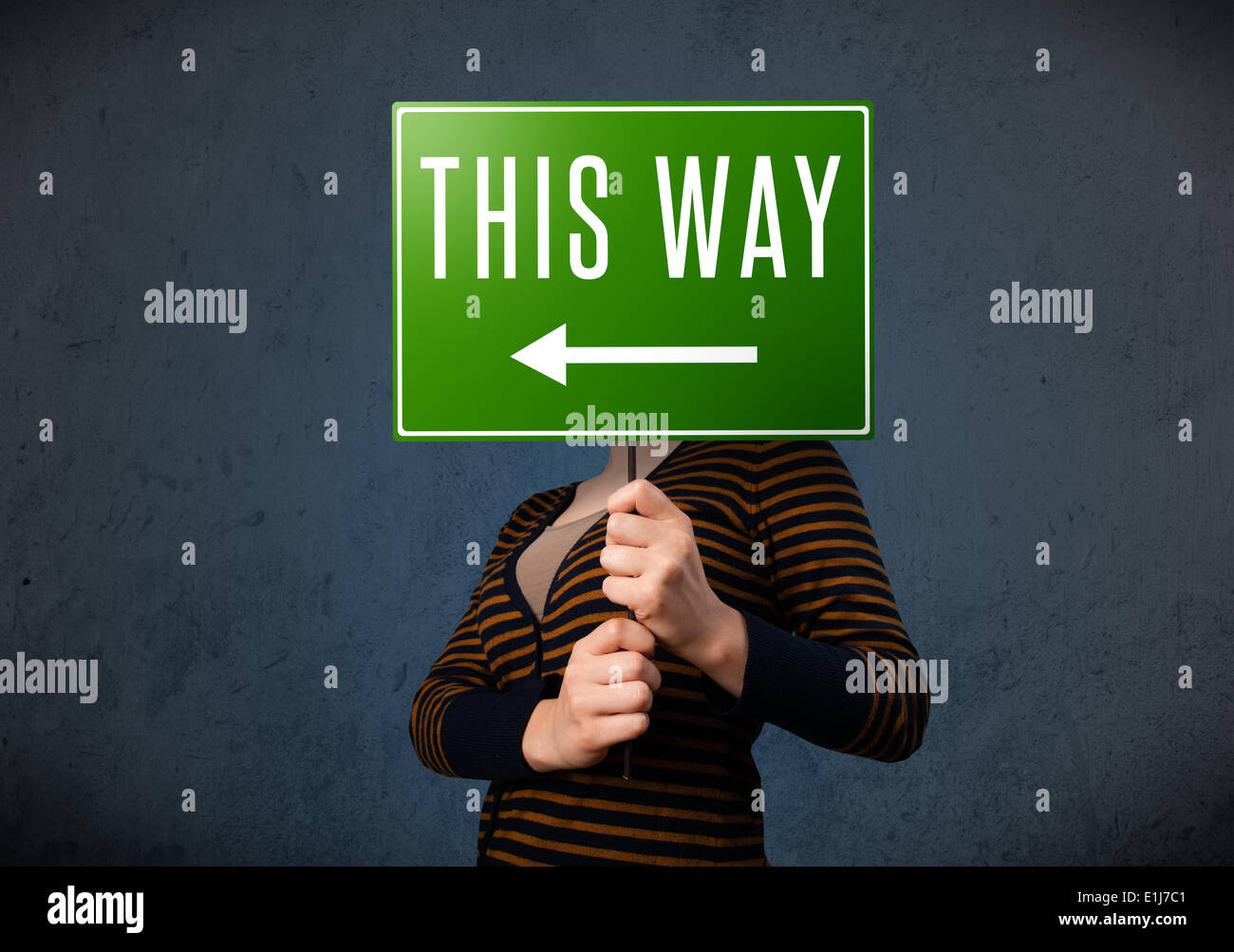 Young woman holding a direction sign Stock Photo - Alamy