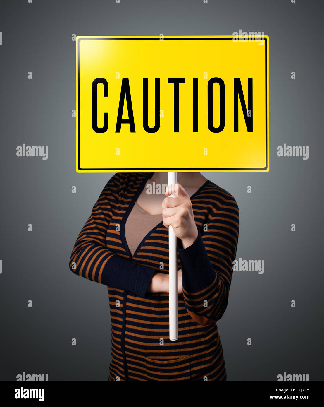 Young woman holding a caution sign Stock Photo - Alamy