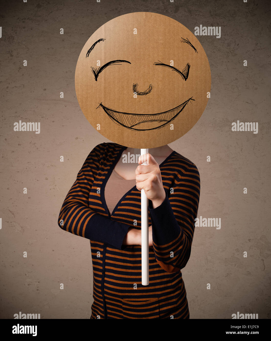 Young woman holding a smiley face board Stock Photo - Alamy