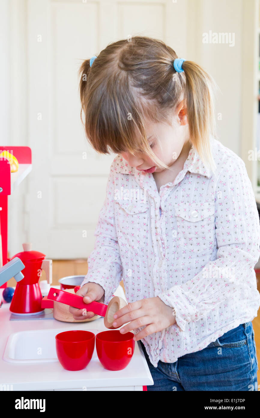 Little girl playing with children's kitchen Stock Photo - Alamy