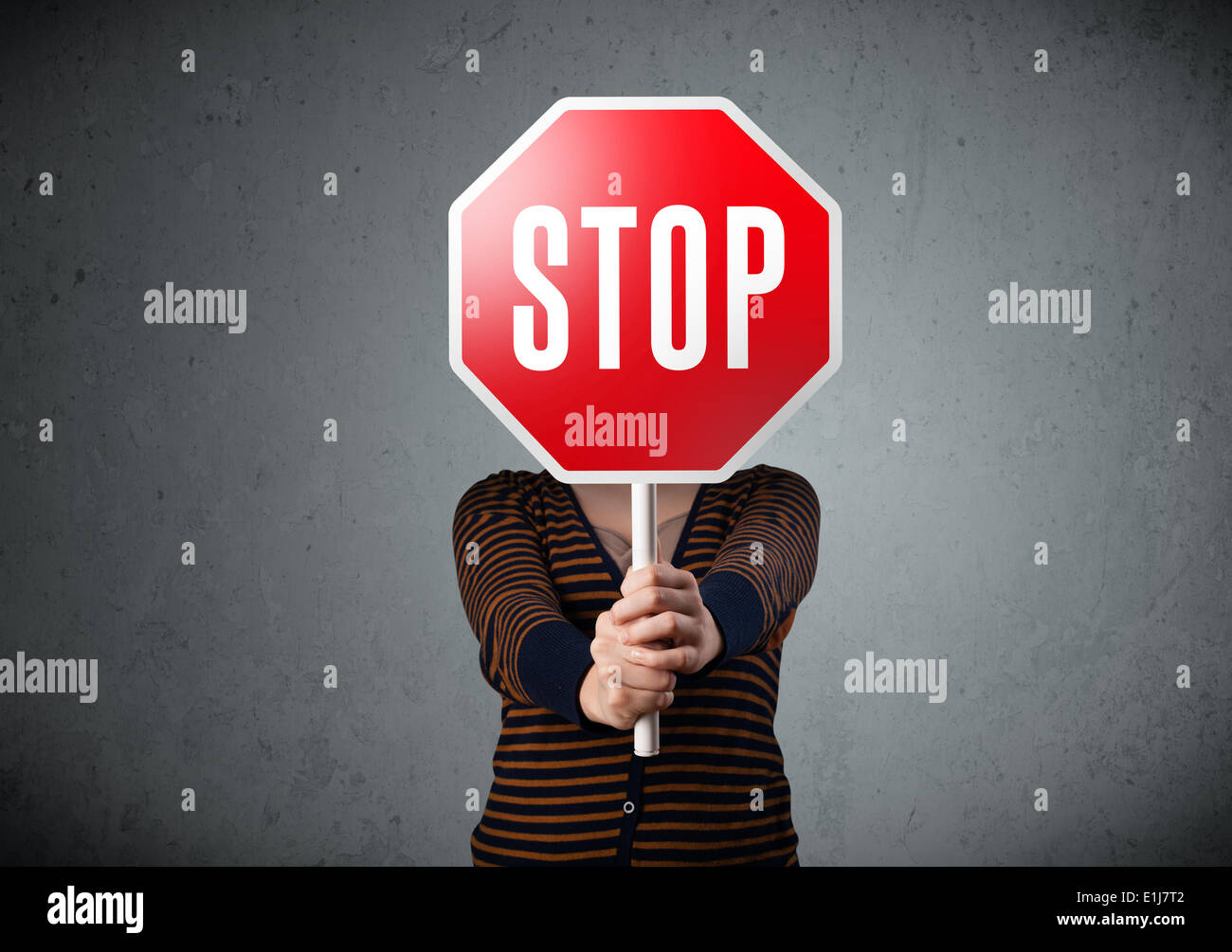 Young woman holding a stop sign Stock Photo - Alamy