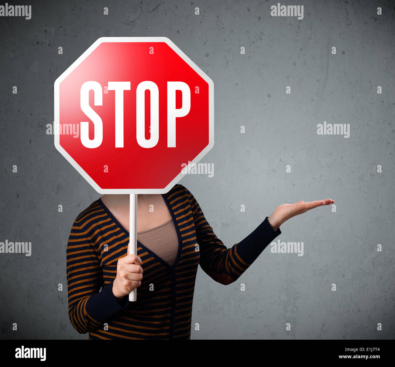 Young woman holding a stop sign Stock Photo - Alamy
