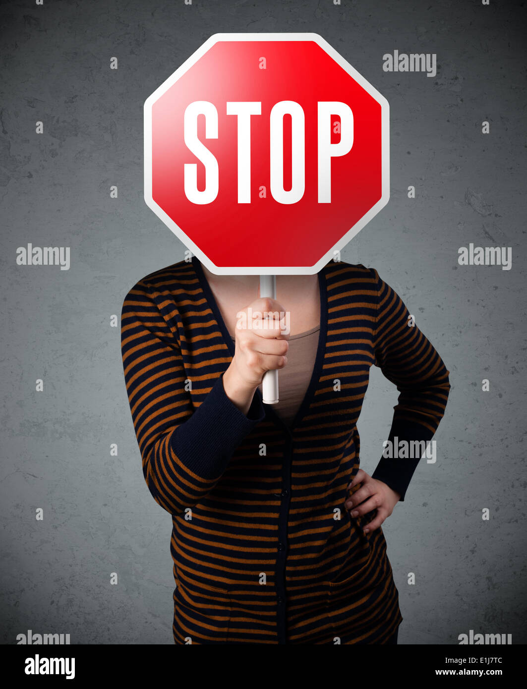 Young woman holding a stop sign Stock Photo - Alamy