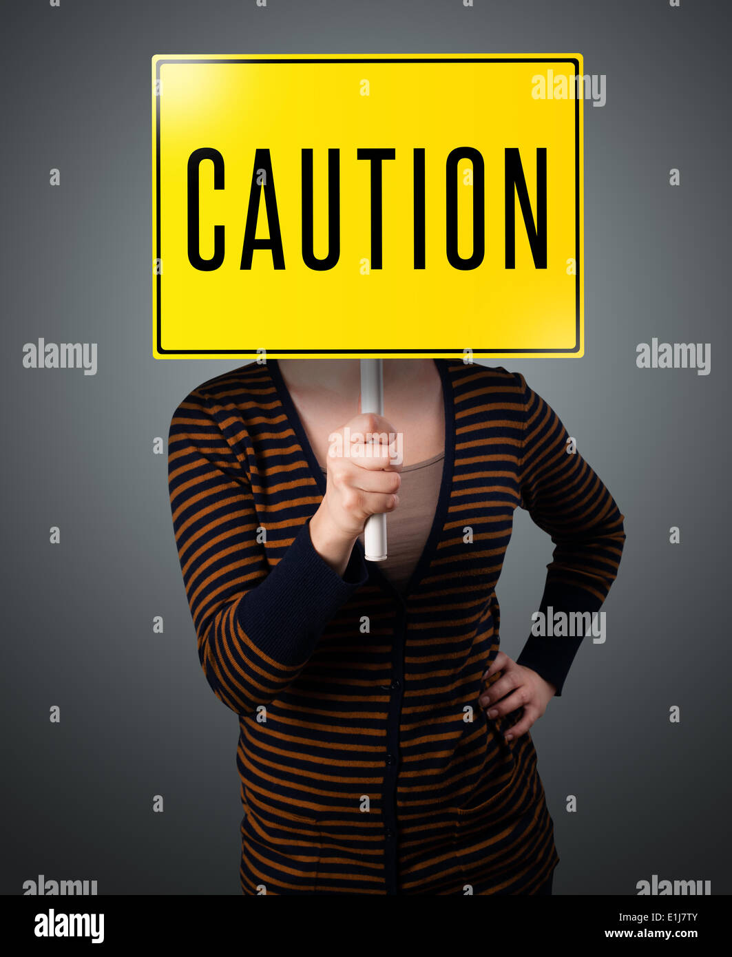 Young woman holding a caution sign Stock Photo - Alamy