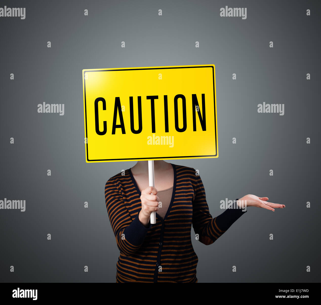 Young woman holding a caution sign Stock Photo - Alamy