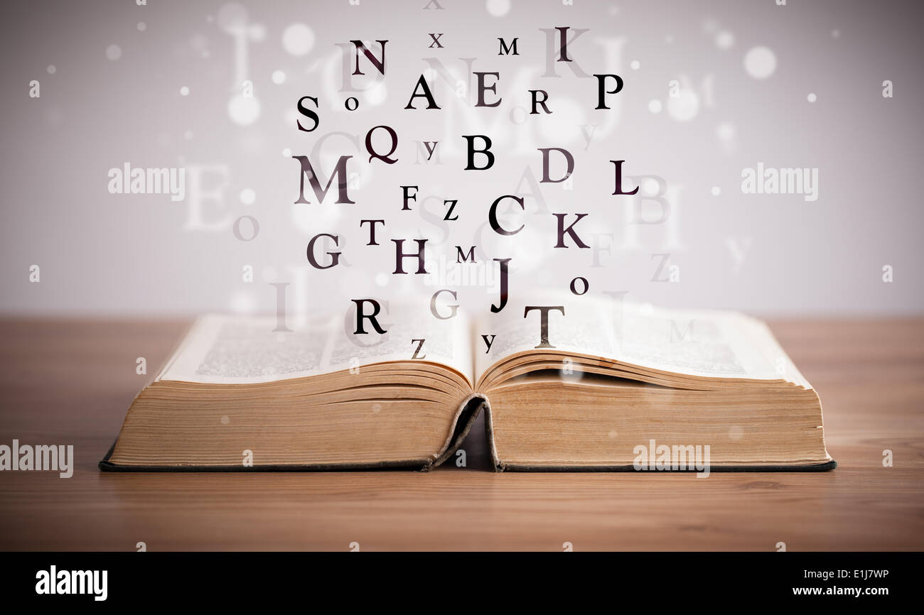 Opened book with flying letters Stock Photo - Alamy