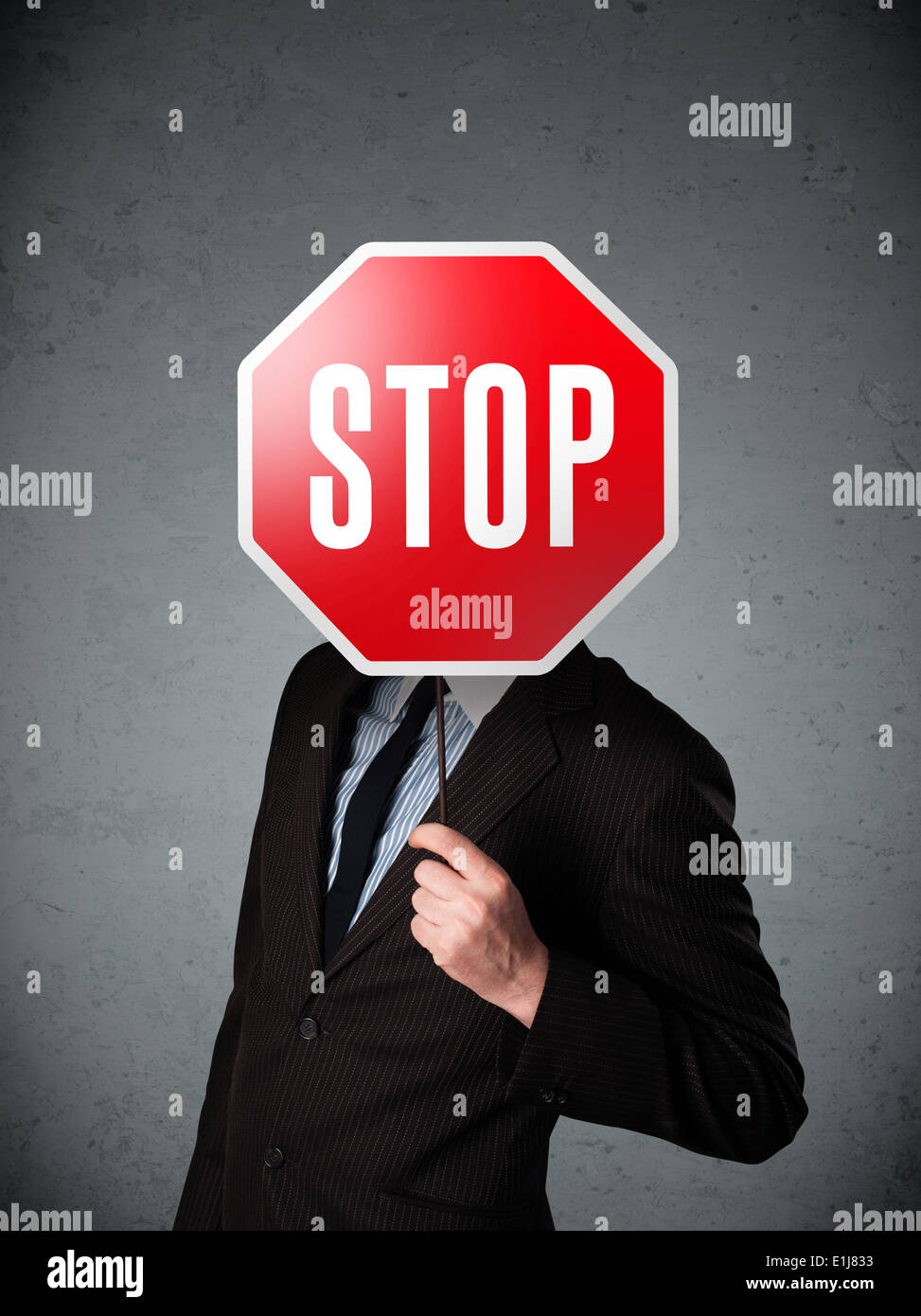 Businessman holding a stop sign Stock Photo - Alamy